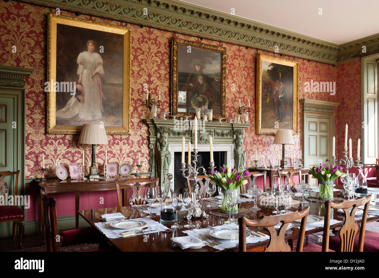 Sumptuous dining room with antiques oil portraits on the red ...