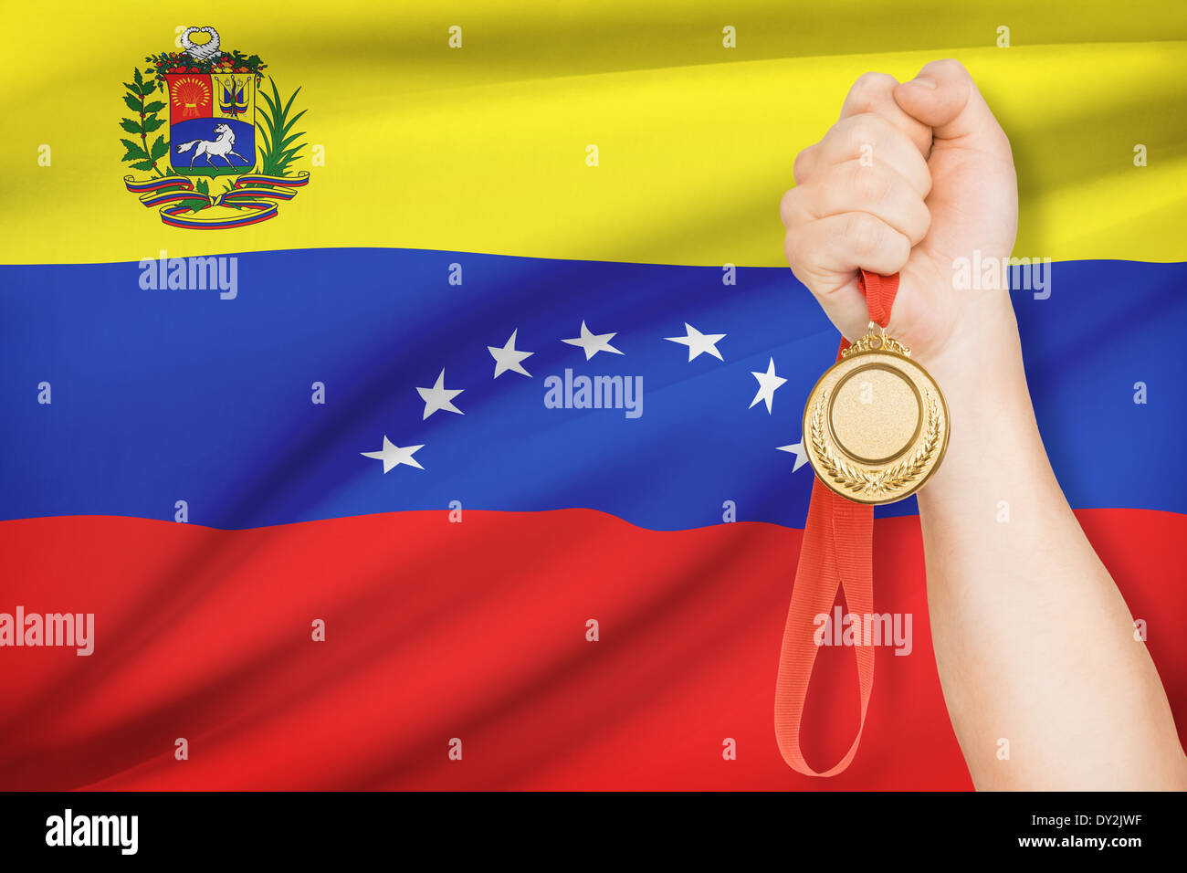Sportsman holding gold medal with flag on background - Bolivarian ...
