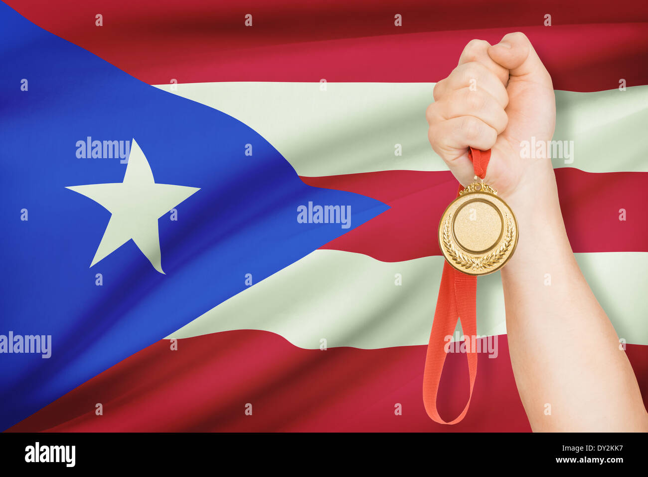 Sportsman holding gold medal with flag on background - Commonwealth of ...