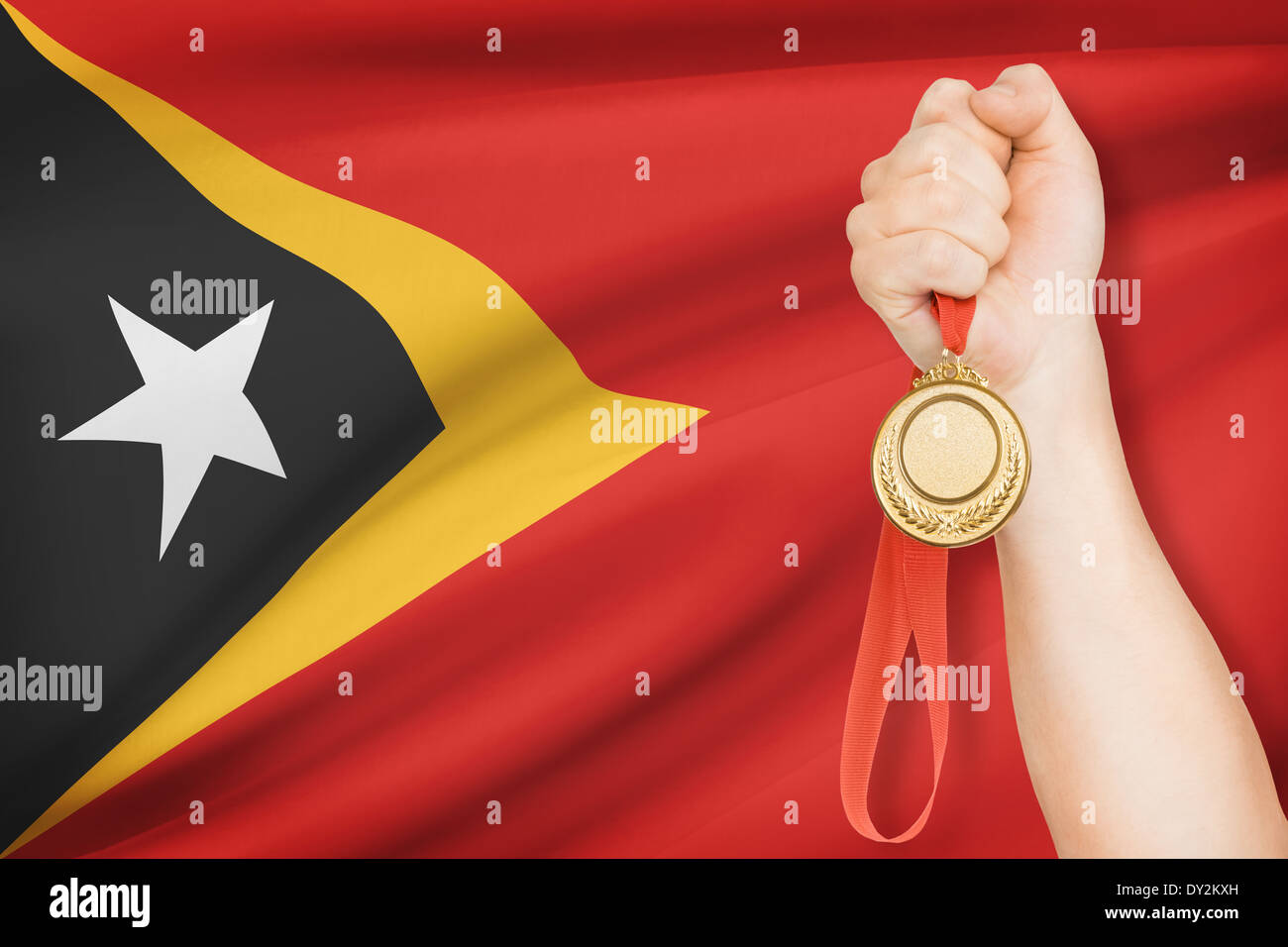 Sportsman holding gold medal with flag on background - Democratic ...