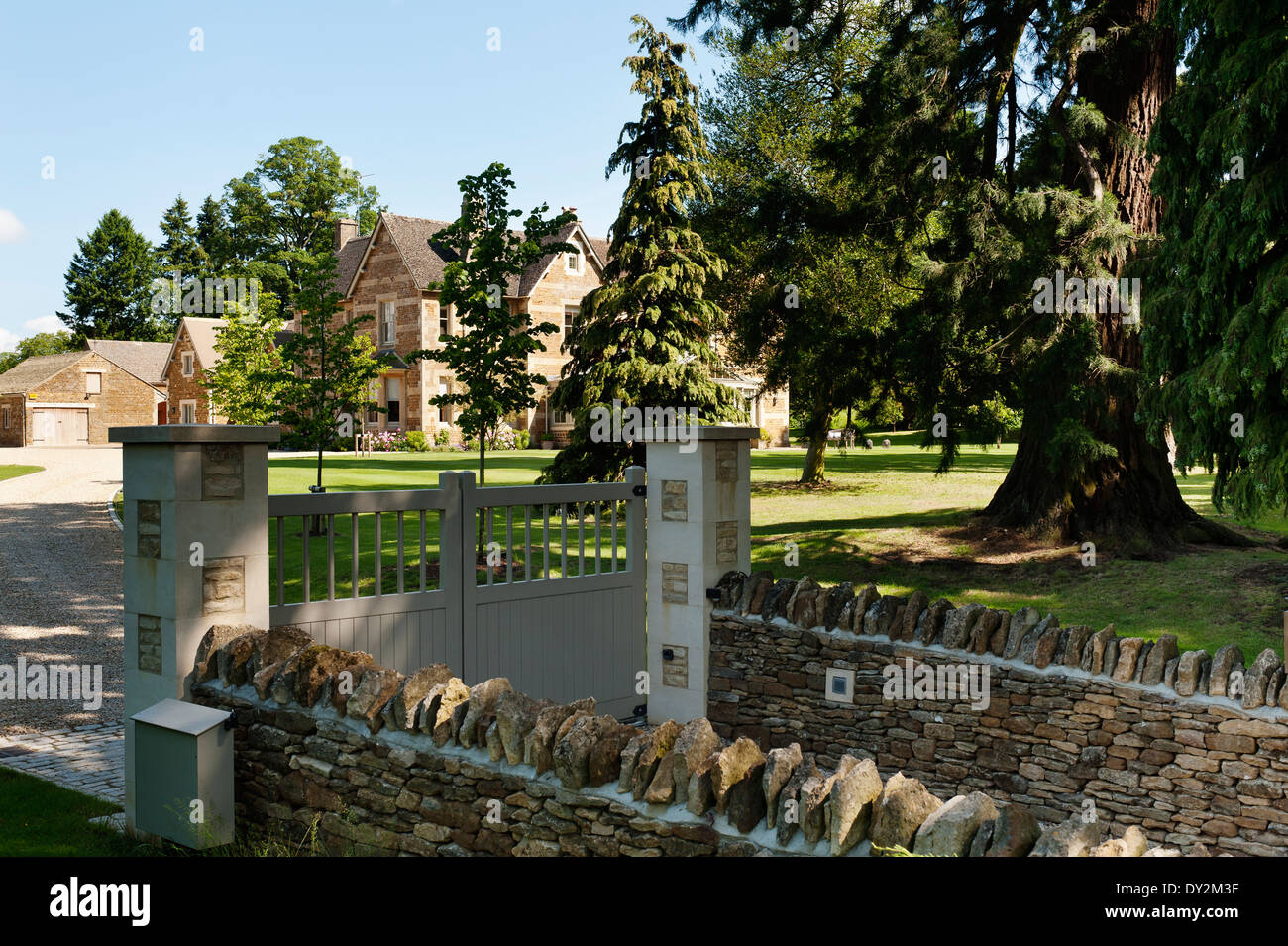 Entrance gates and driveway of victorian farmhoue house with park-like ...