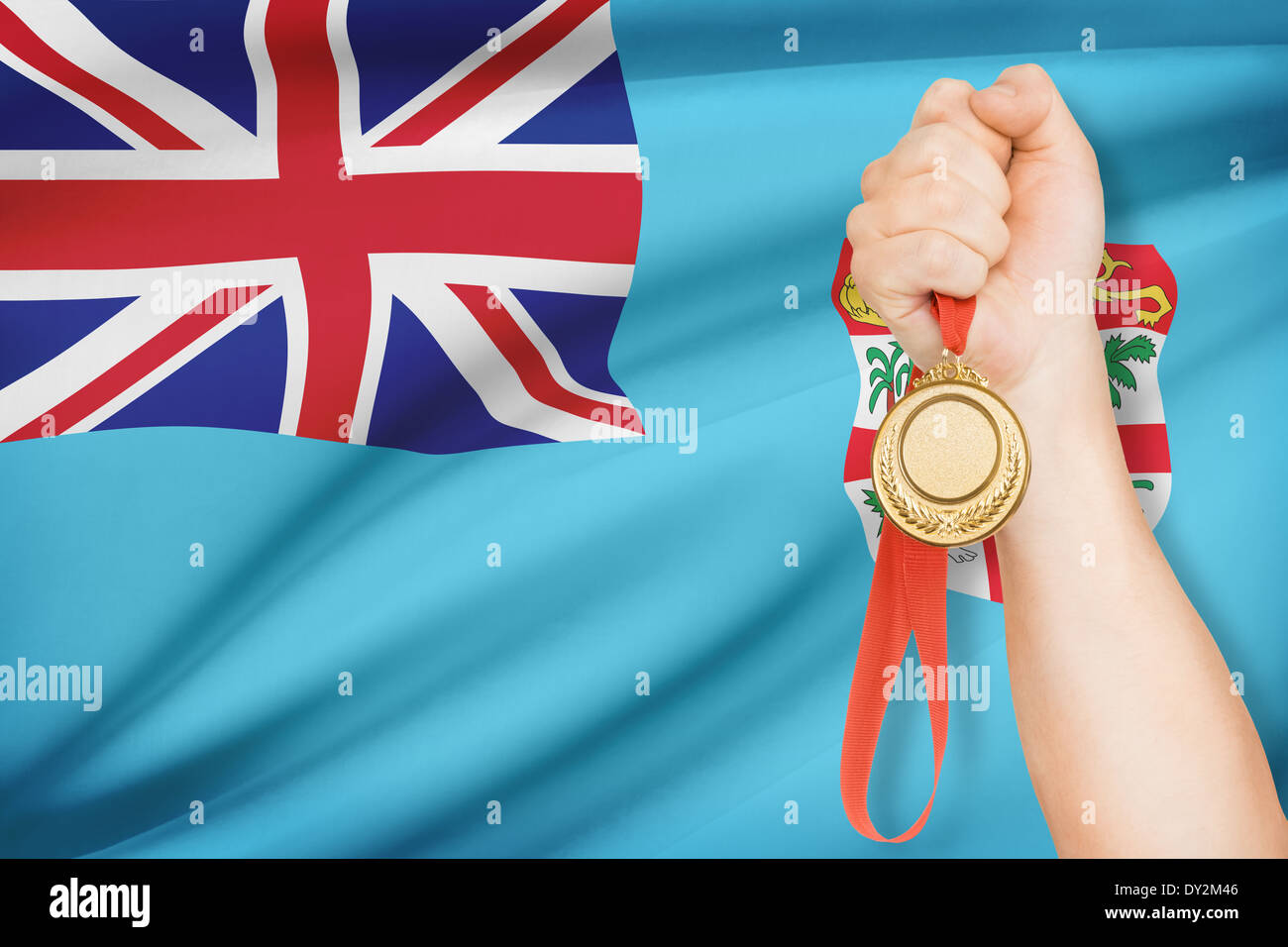 Sportsman holding gold medal with flag on background - Republic of Fiji ...