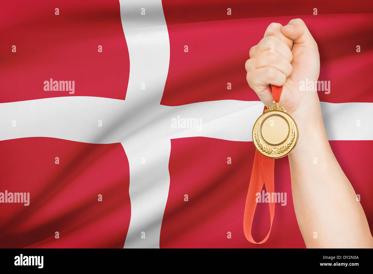 Sportsman holding gold medal with flag on background - Kingdom of ...