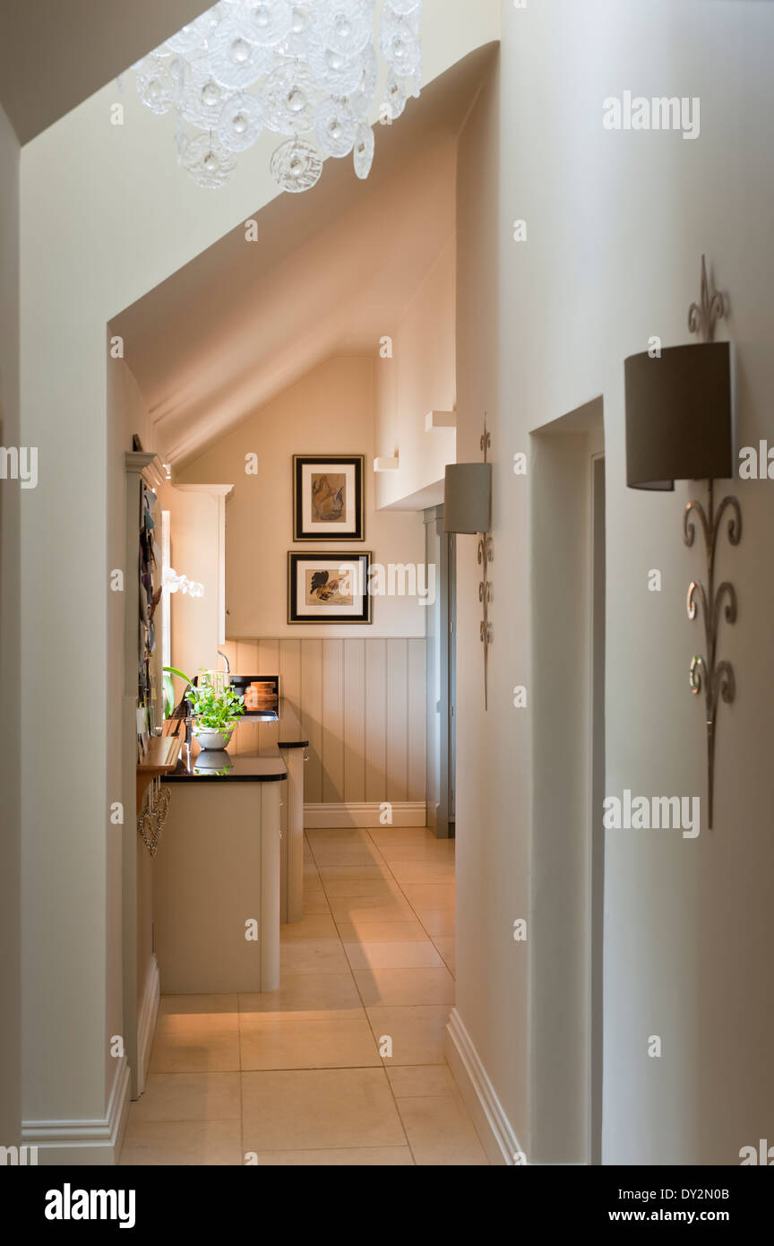 Corridor with slanted ceiling, glass chandelier and stylish wall ...