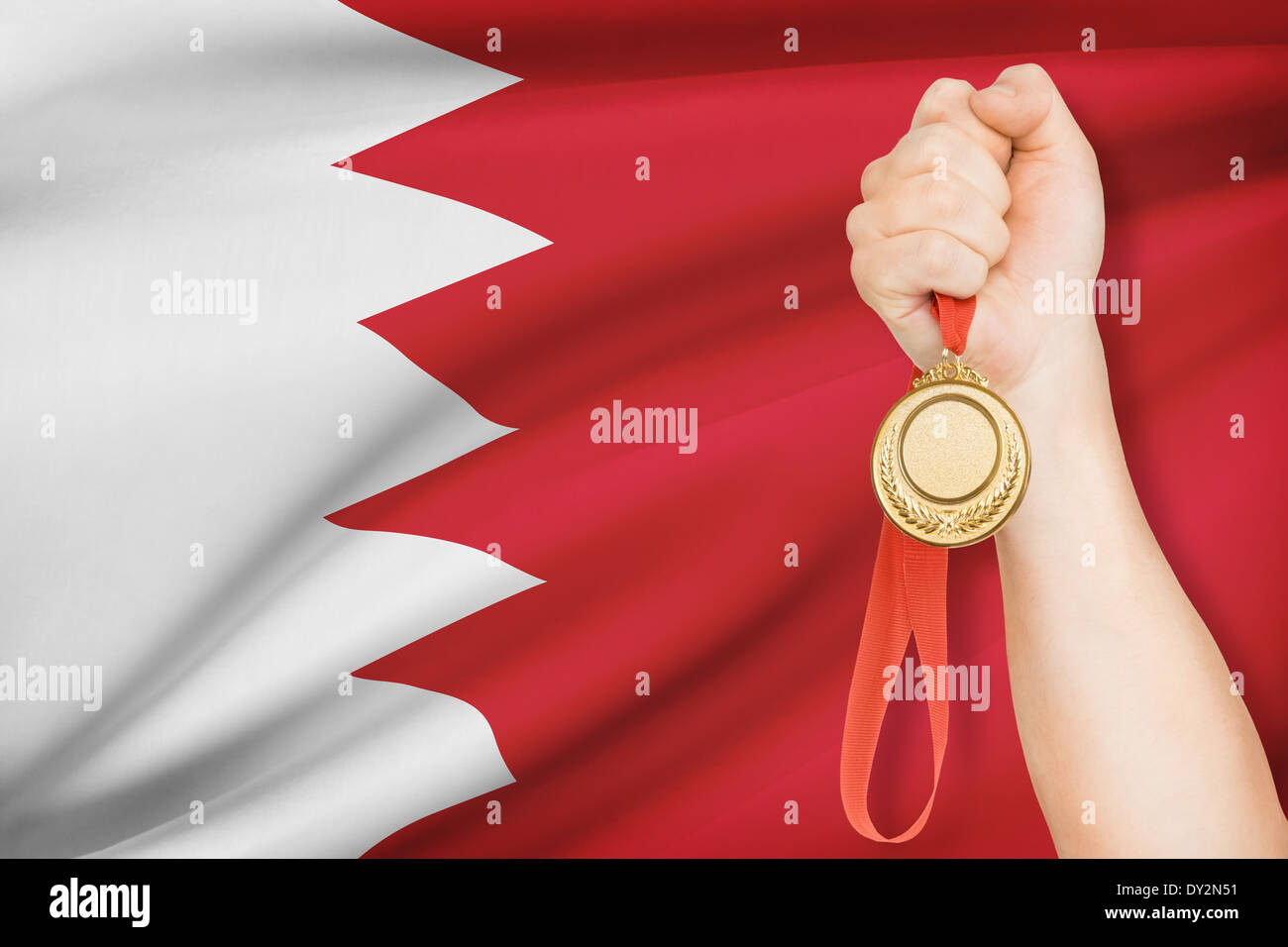 Sportsman holding gold medal with flag on background - Kingdom of ...