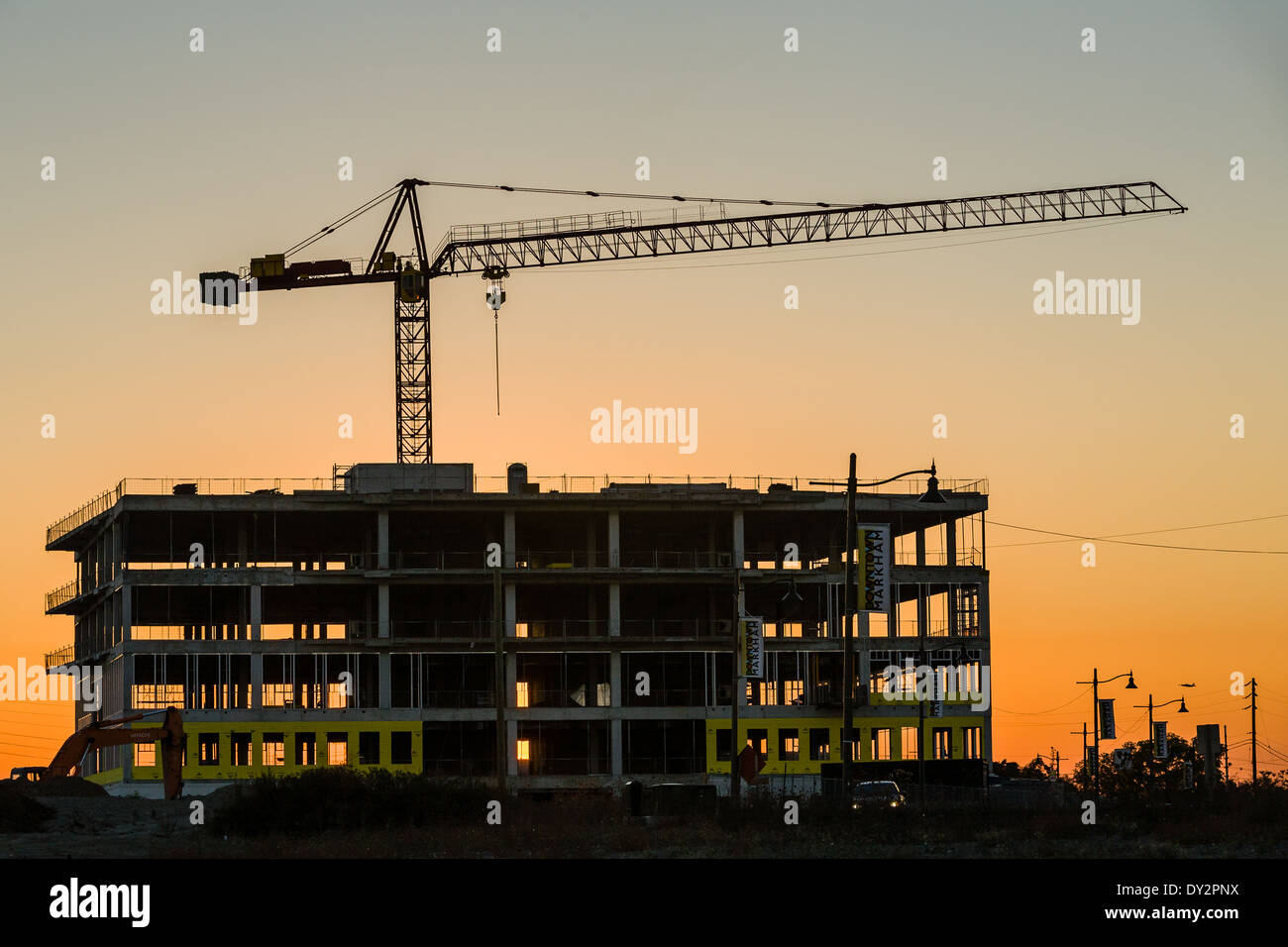 Construction cranes with building skeleton against sunset background Stock Photo - Alamy