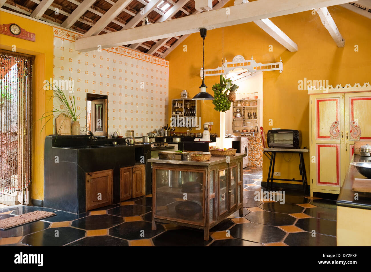 Freestanding unit on black and yellow tiled floor of Goan kitchen Stock ...