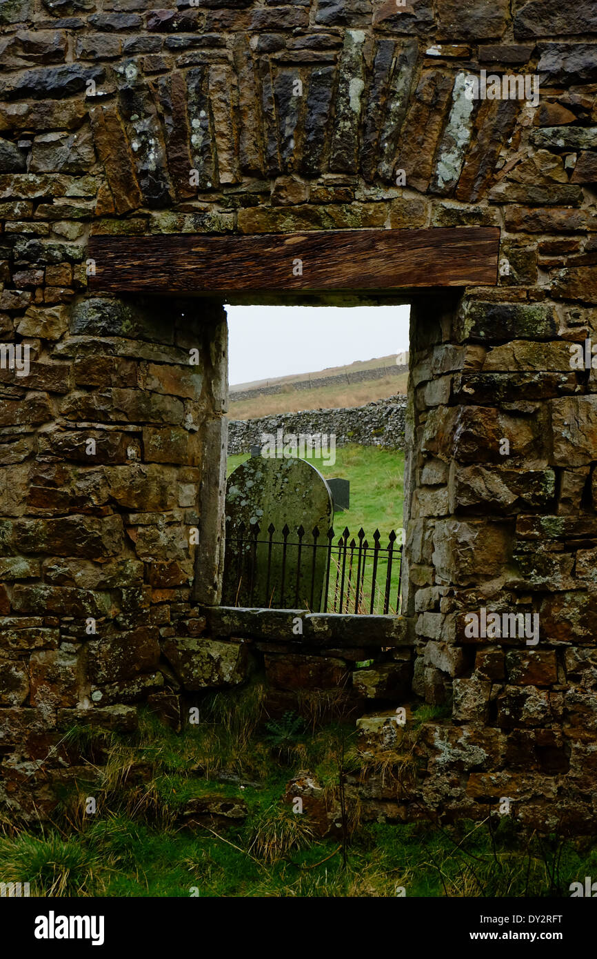 View framed by a church ruin window of misty hills and the old ...