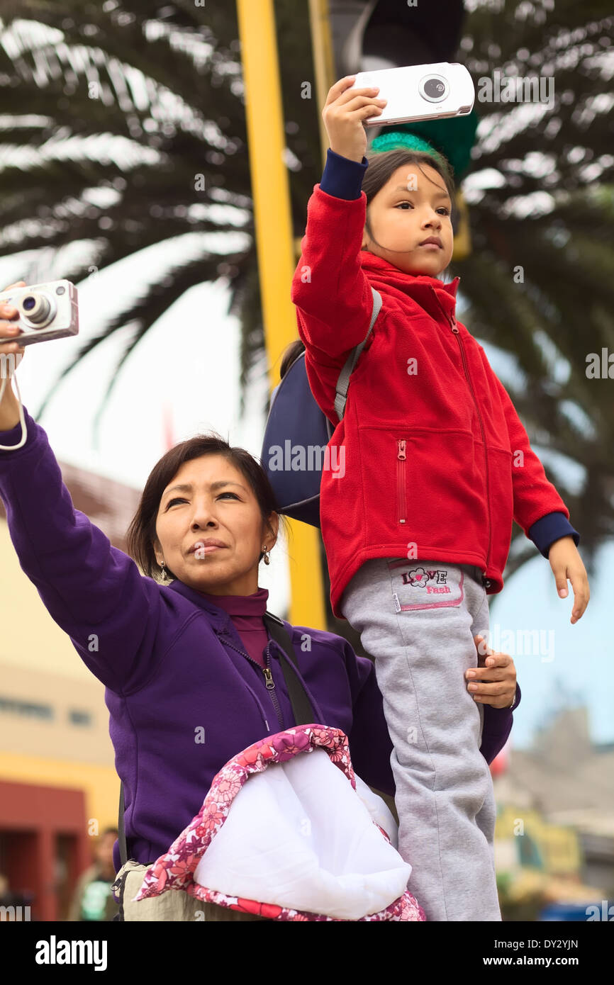 Unidentified woman and child taking photos on the Wong Parade in ...