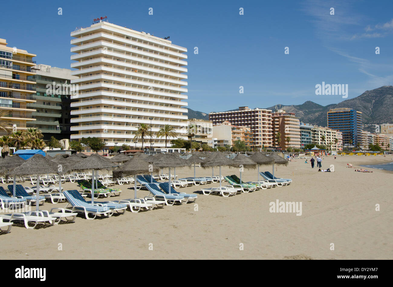 Beach with sunbeds and high-rise hotels behind. Costa del Sol ...