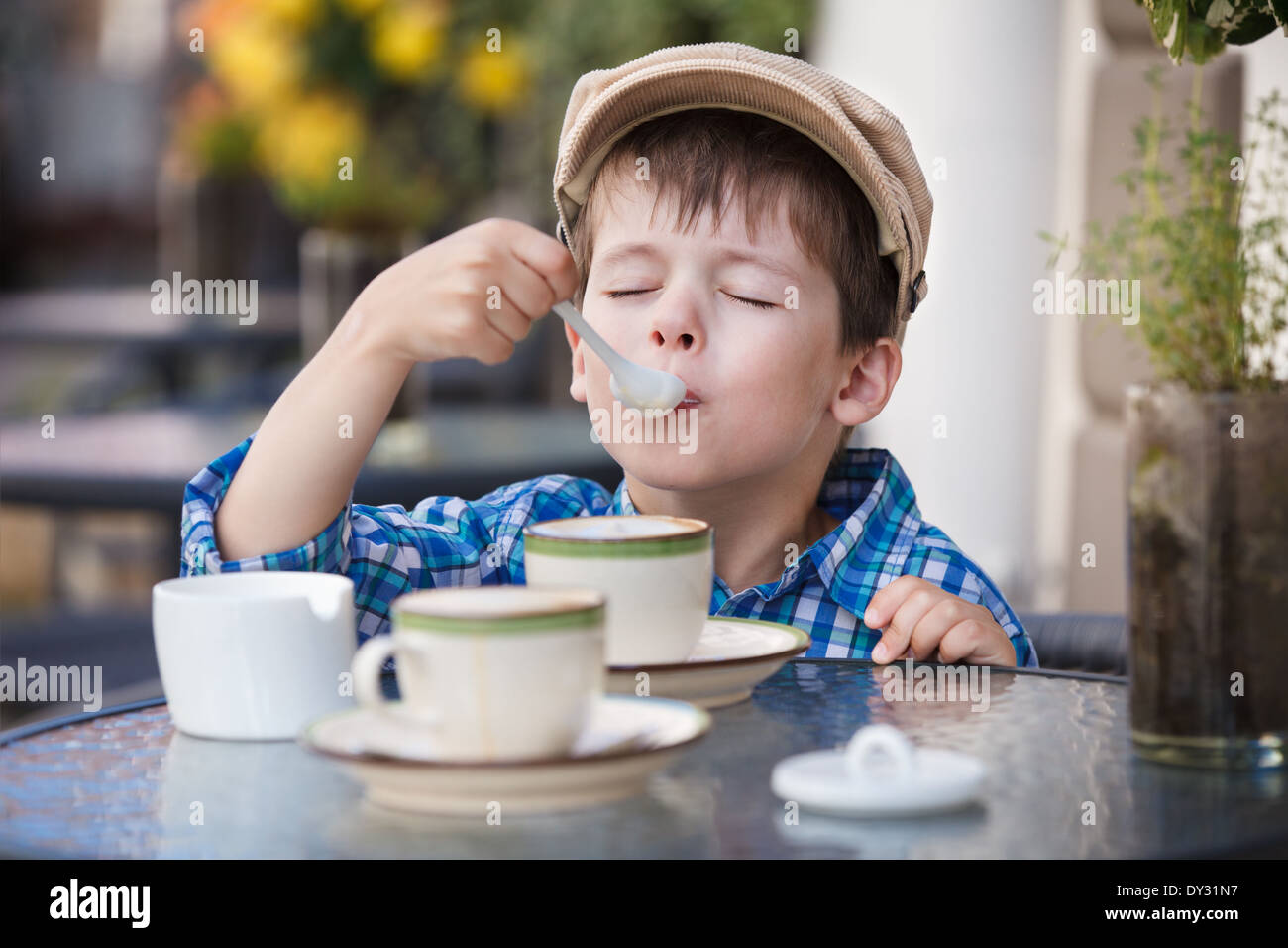 Cute little boy drinking milkshake in outdoor restaurant Stock Photo ...