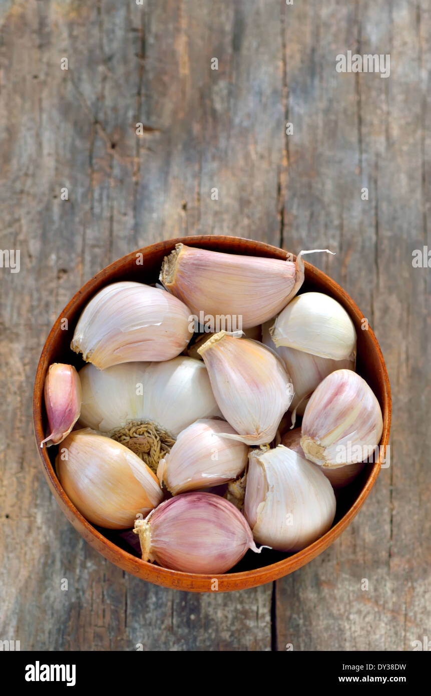 garlic in a wooden bowl isolated on old background Stock Photo - Alamy
