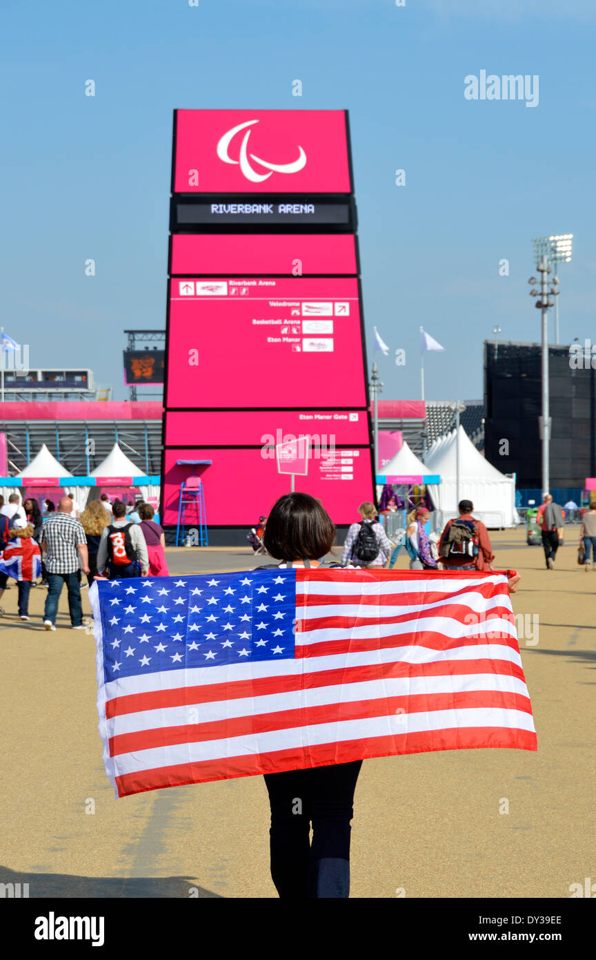 Woman draping stars and stripes American flag over her shoulders near ...
