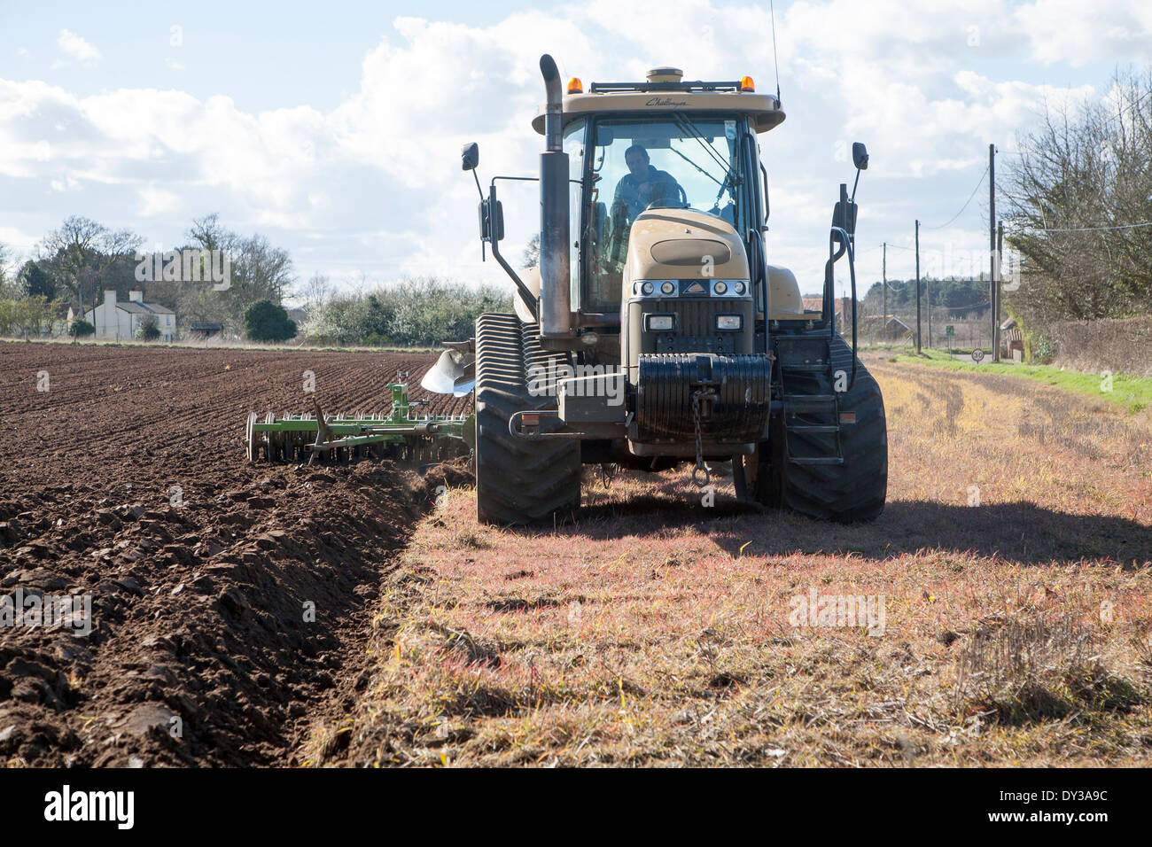 Challenger tracked tractor ploughing and pressing the soil in an arable ...