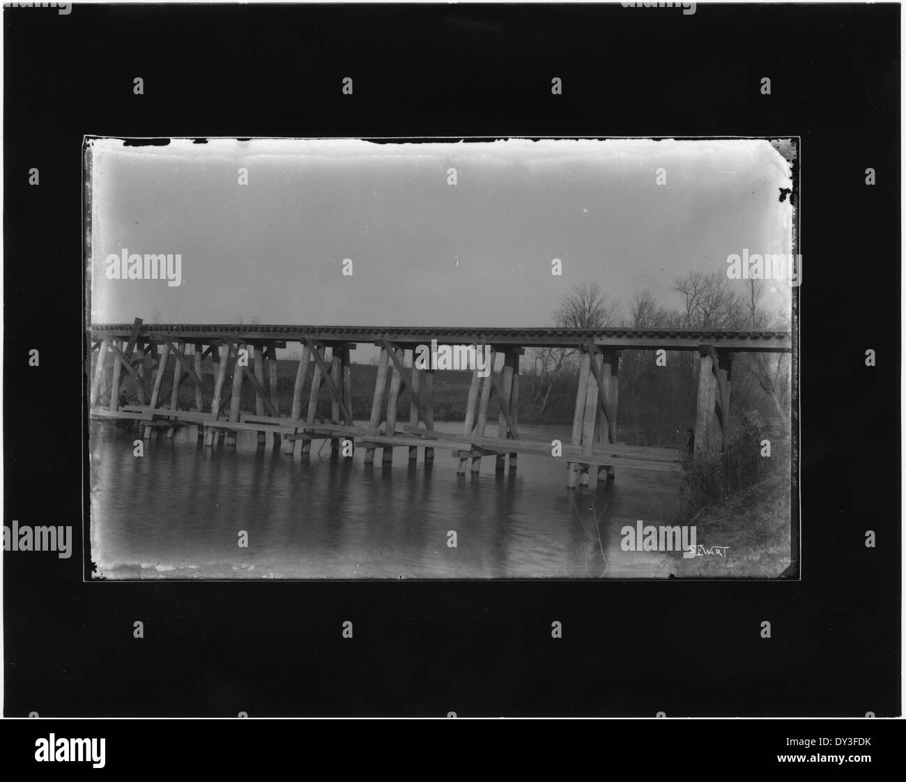 A historical photograph of a trestle bridge spanning a bayou ...