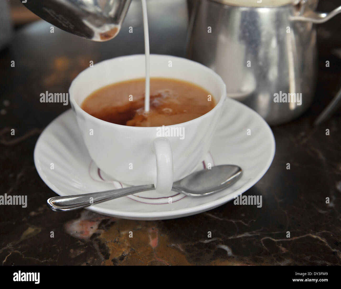 A traditional British cup of tea with milk being poured into the tea ...