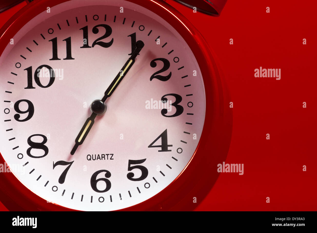 A red vintage alarm clock face on a red background Stock Photo - Alamy