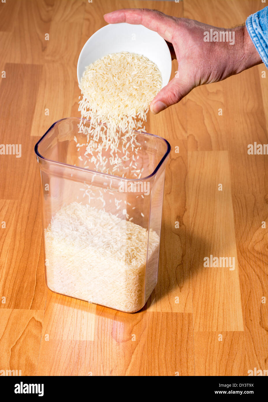 Pouring rice into a container Stock Photo - Alamy