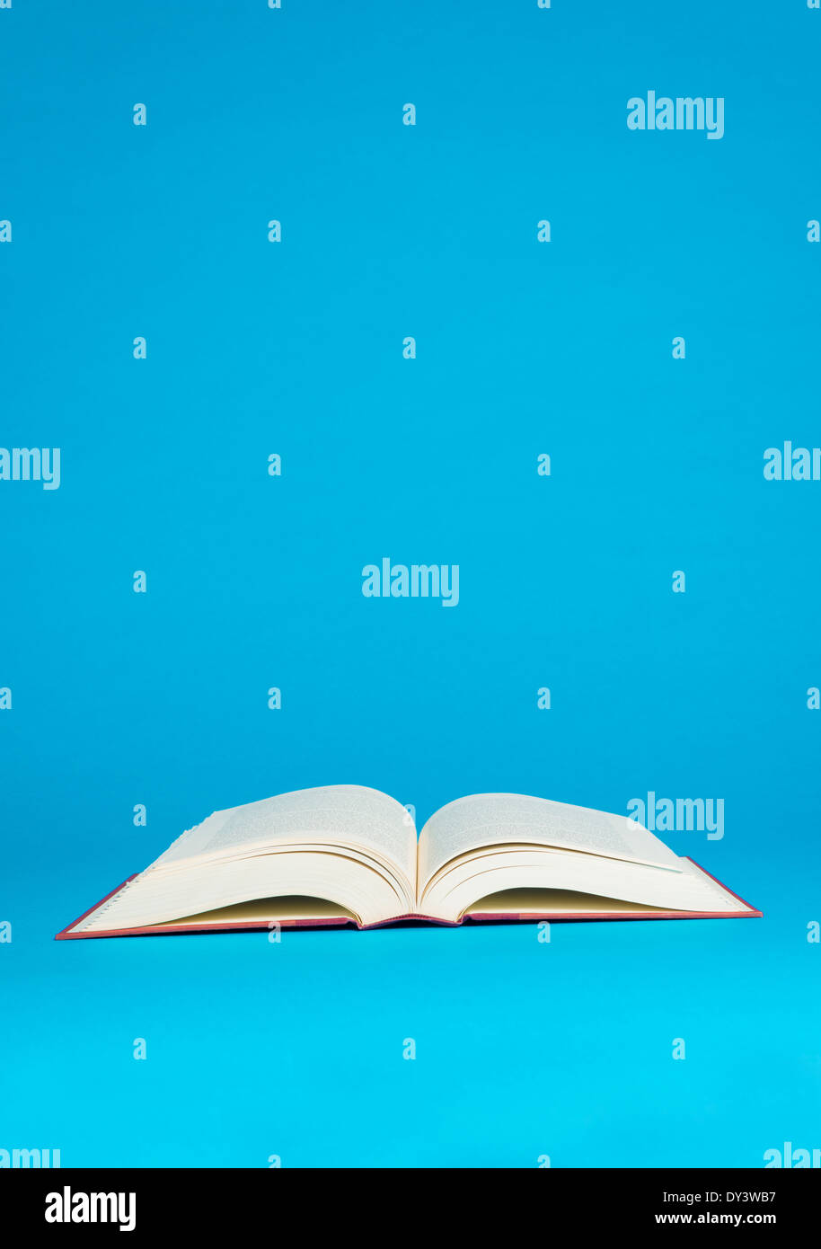 An open book on a bright blue background Stock Photo - Alamy