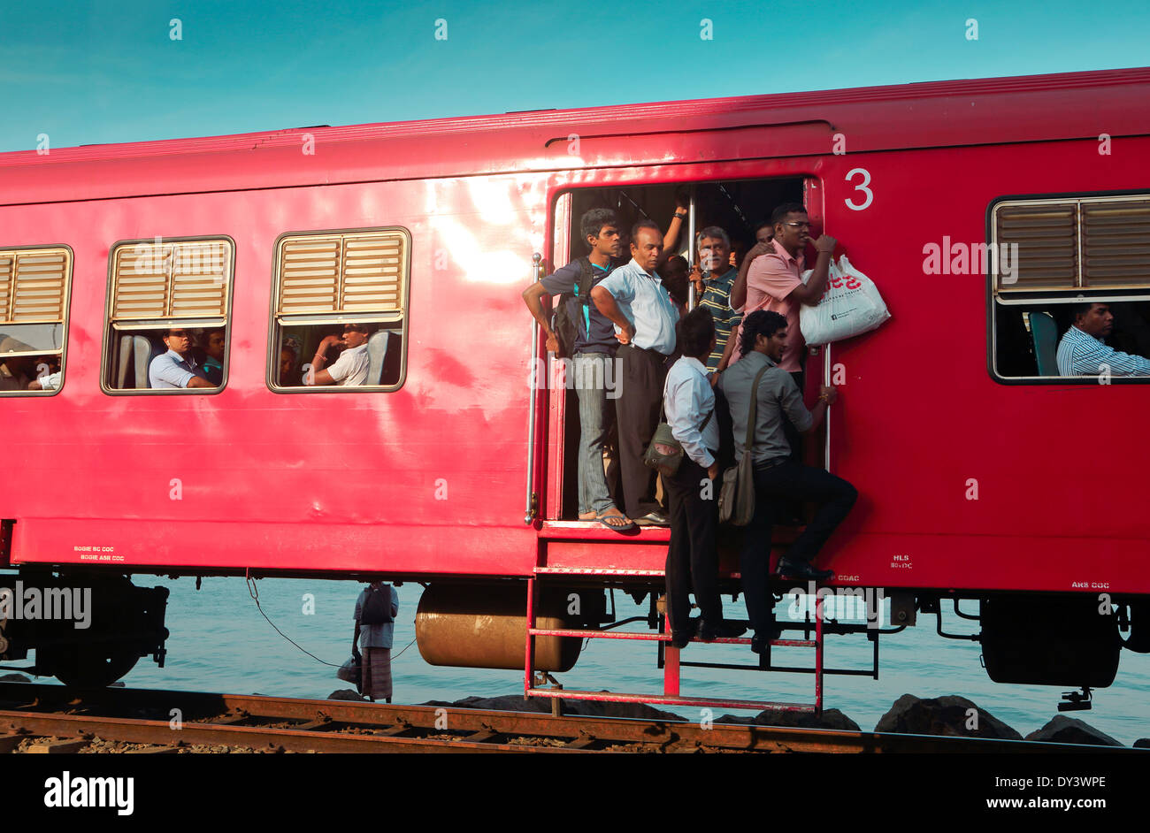 Train at Bambalapitiya Railway station with male passengers hanging out ...