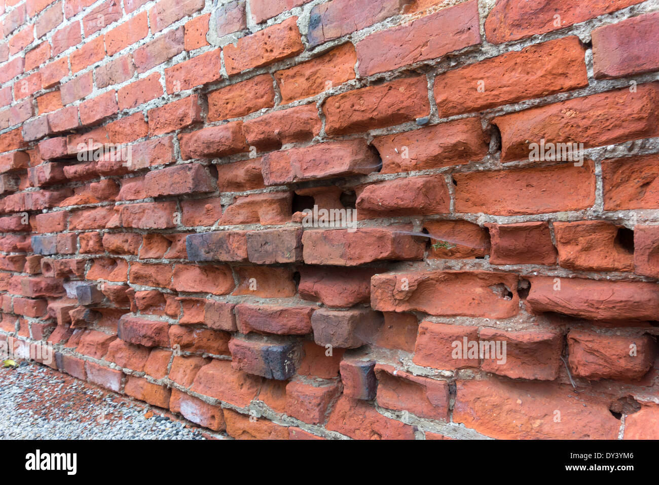 A red brick wall severely weather damaged mainly by frost spalling ...