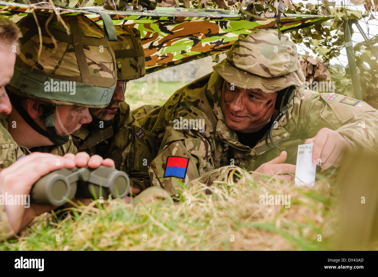 A senior officer gives instructions to soldiers as they hide underneath ...