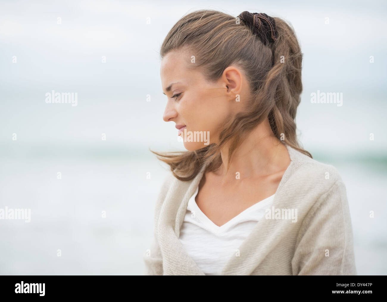 Portrait of relaxed young woman on cold beach Stock Photo - Alamy