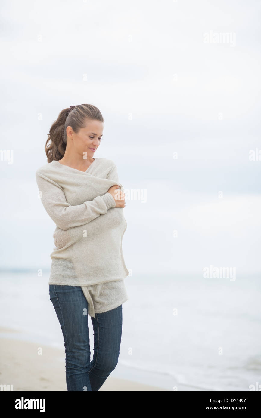 Young woman walking on cold beach Stock Photo - Alamy