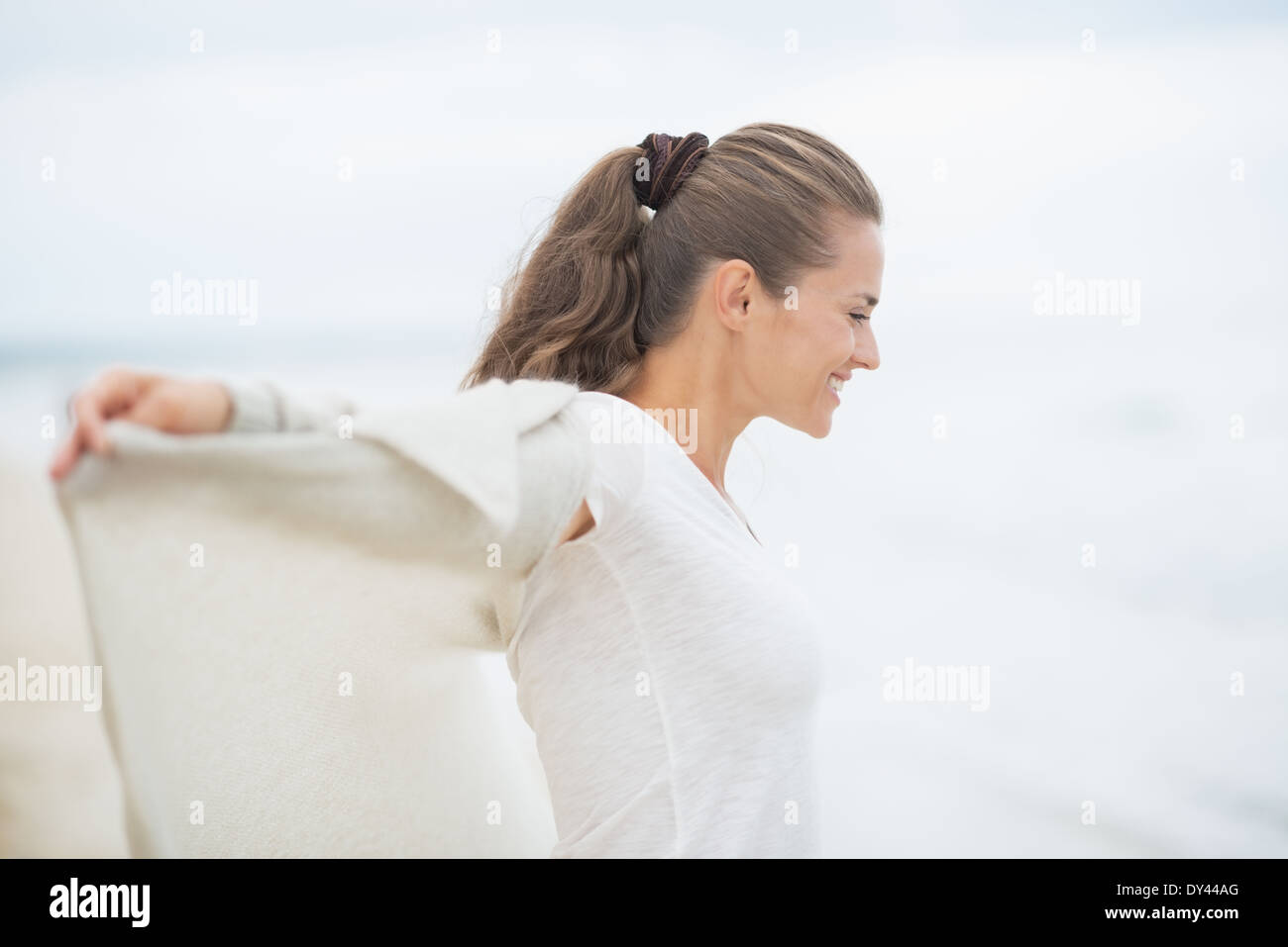 Happy young woman on cold beach rejoicing Stock Photo - Alamy