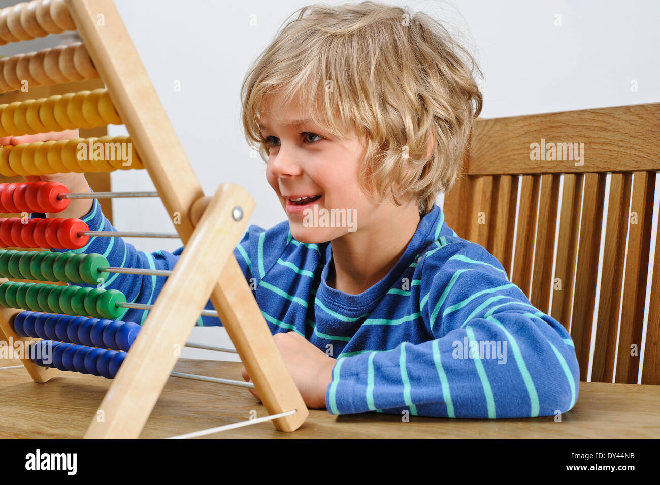 A young boy learns to count using an abacus Stock Photo - Alamy