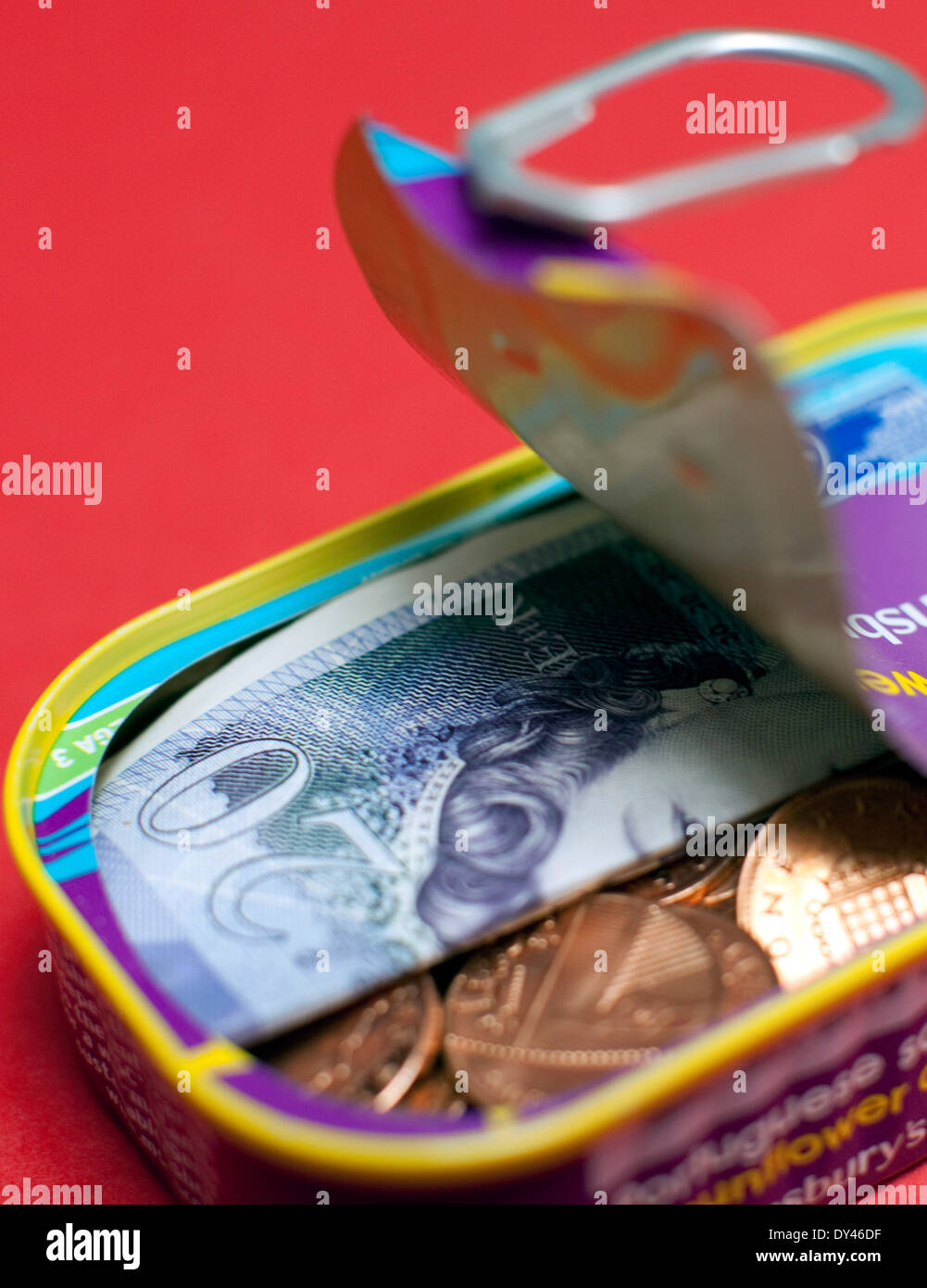 Opening can to reveal cash inside, London Stock Photo - Alamy
