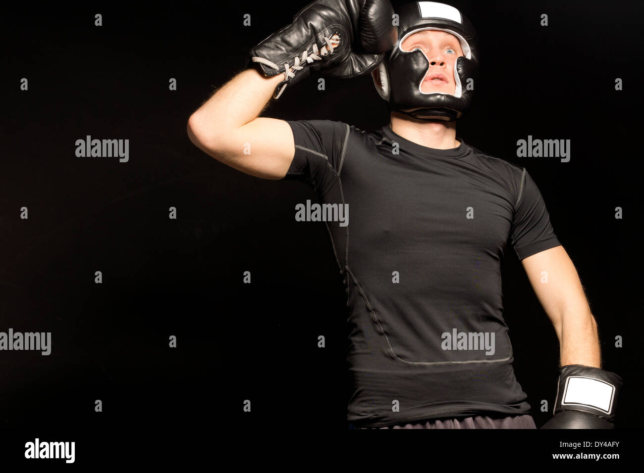 Boxer standing raising his fist to his head as he looks up into the air ...