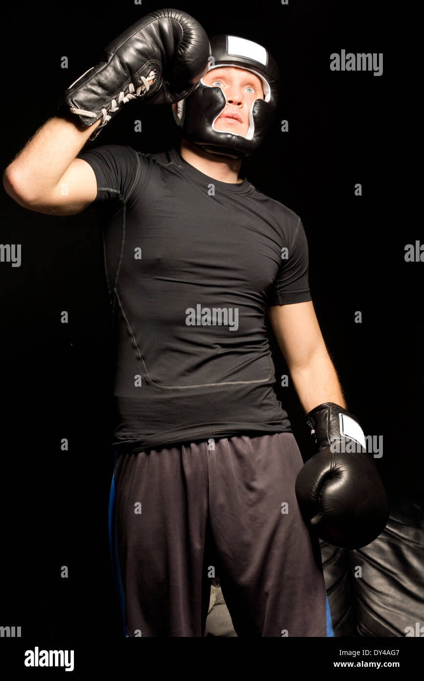 Low angle view of a fit muscular young boxer in boxing gloves and a ...
