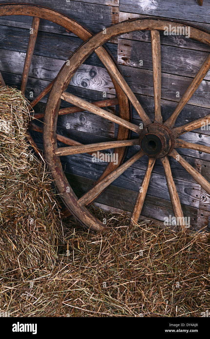 The old wooden wheel on a hay Stock Photo - Alamy