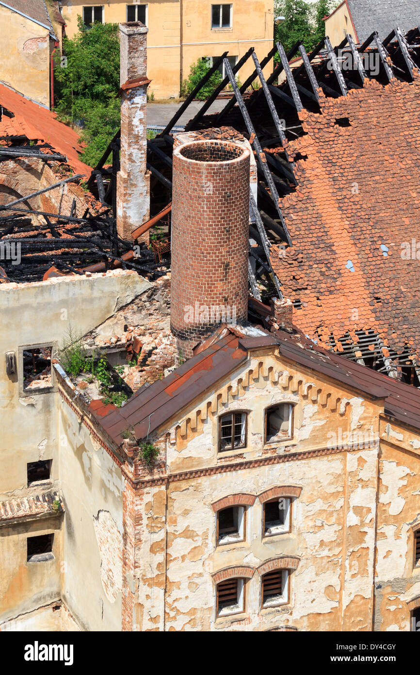 A ruined and burned down old factory with traditional chimney Stock ...