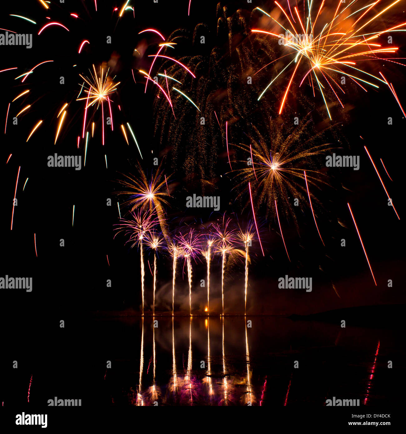 Bursts of Pink Fireworks reflected in a murky lake Stock Photo - Alamy