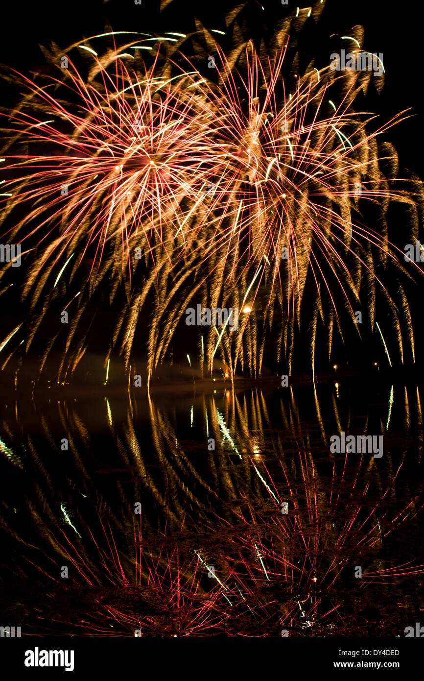 Red and Orange Fireworks reflected in a murky lake Stock Photo - Alamy