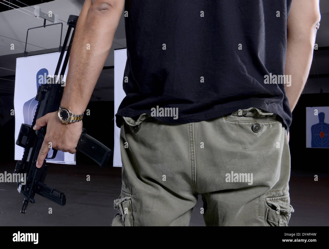 man standing and armed at gun range with firearm Stock Photo - Alamy
