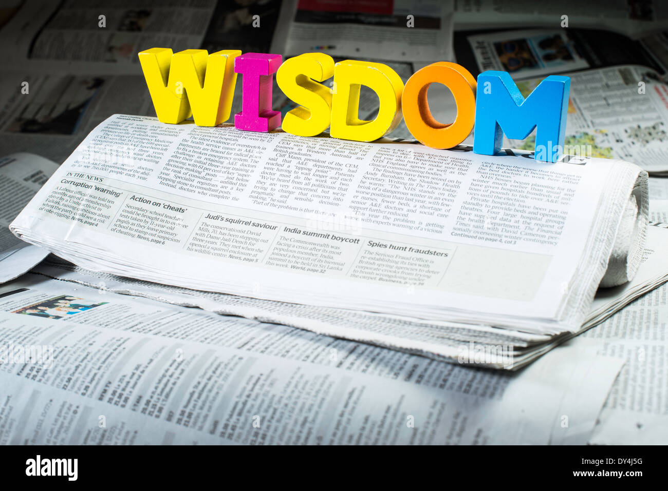 Word wisdom on newspaper.Wooden letters Stock Photo - Alamy