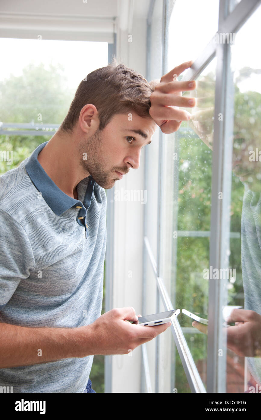 Man smartphone looking out window hi-res stock photography and images ...