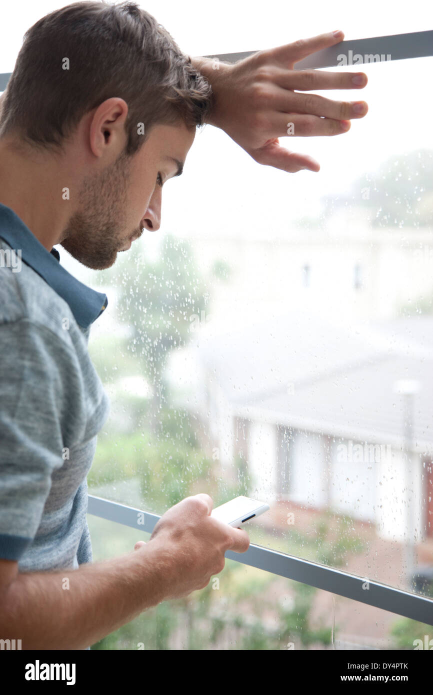 Man smartphone looking out window hi-res stock photography and images ...
