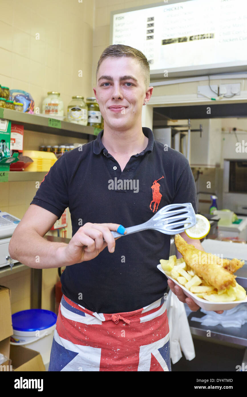 Staff member holding a lemon slice and portion of fish and chips at the ...