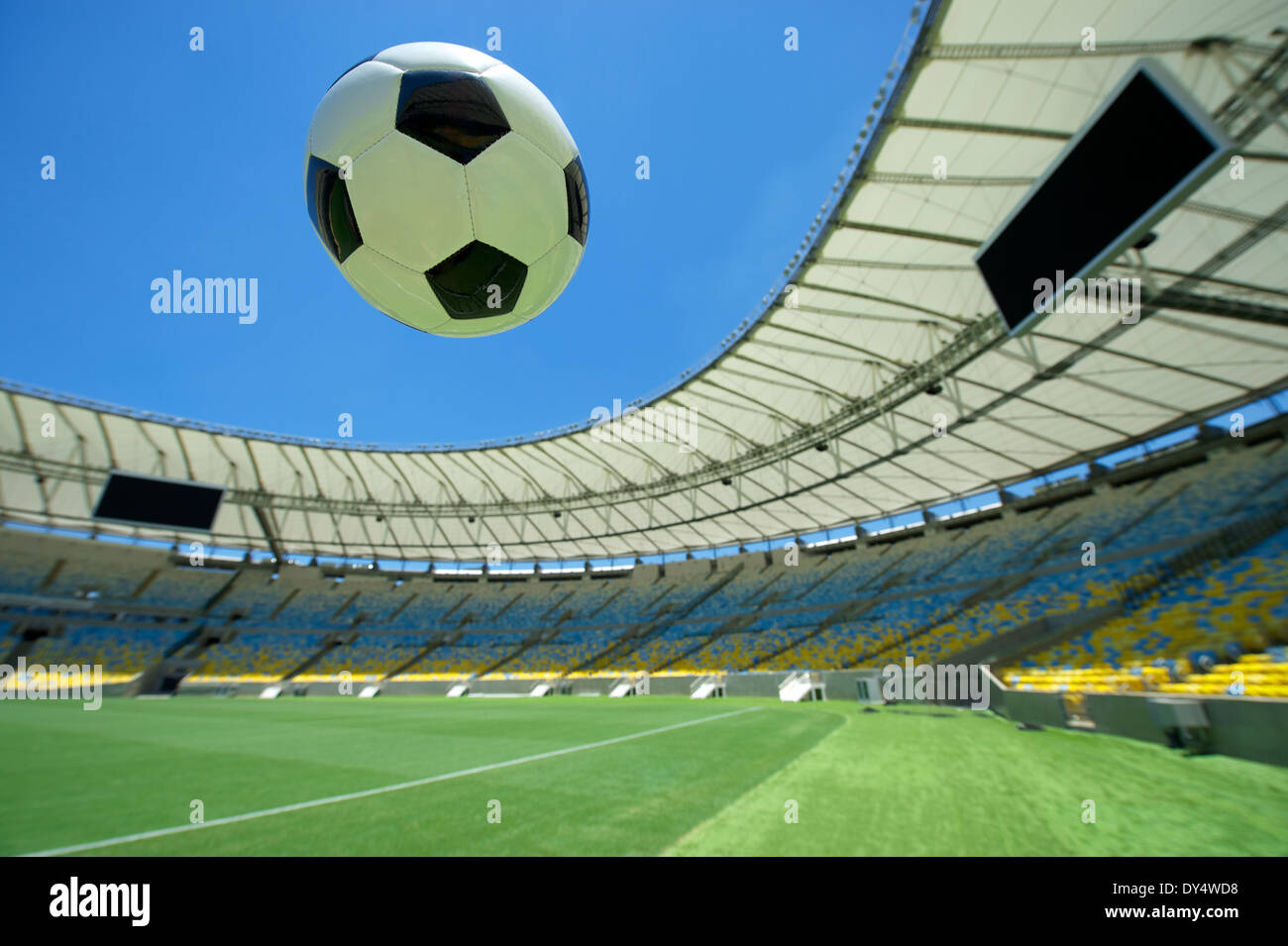 Football soccer ball flying over bright green grass stadium pitch Stock ...