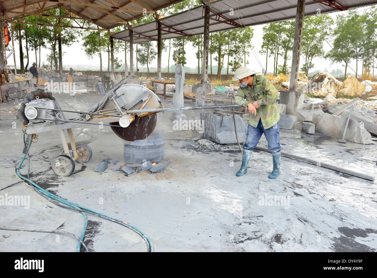 Stone cutter cutting rock with saw to carve into large ornaments for ...