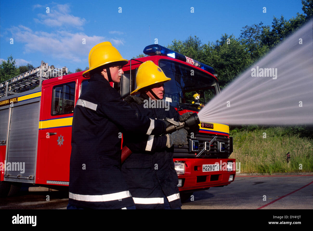 Firefighters spraying water during training Stock Photo - Alamy