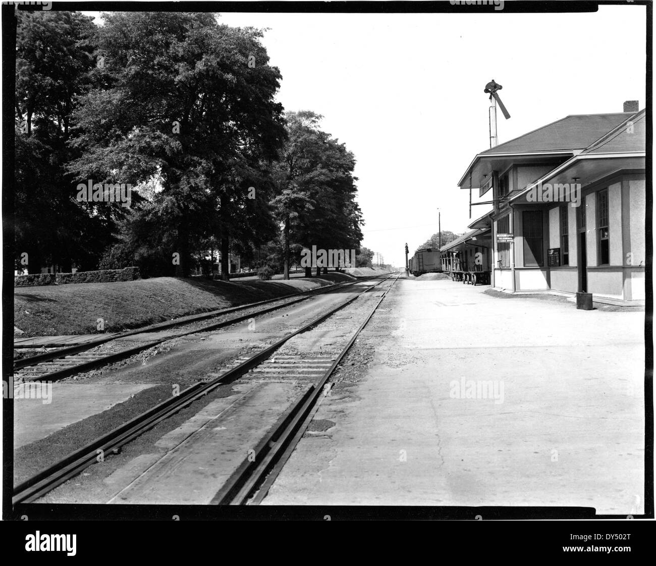 A photograph showing railroad tracks and a depot, representing an ...