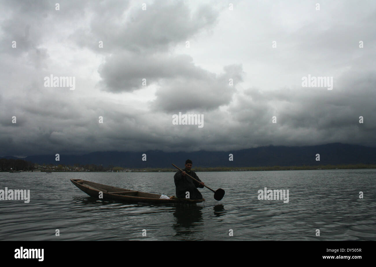 Srinagar, Indian Administered Kashmir. 7th April, 2014. A kashmiri man rides his boat while ...