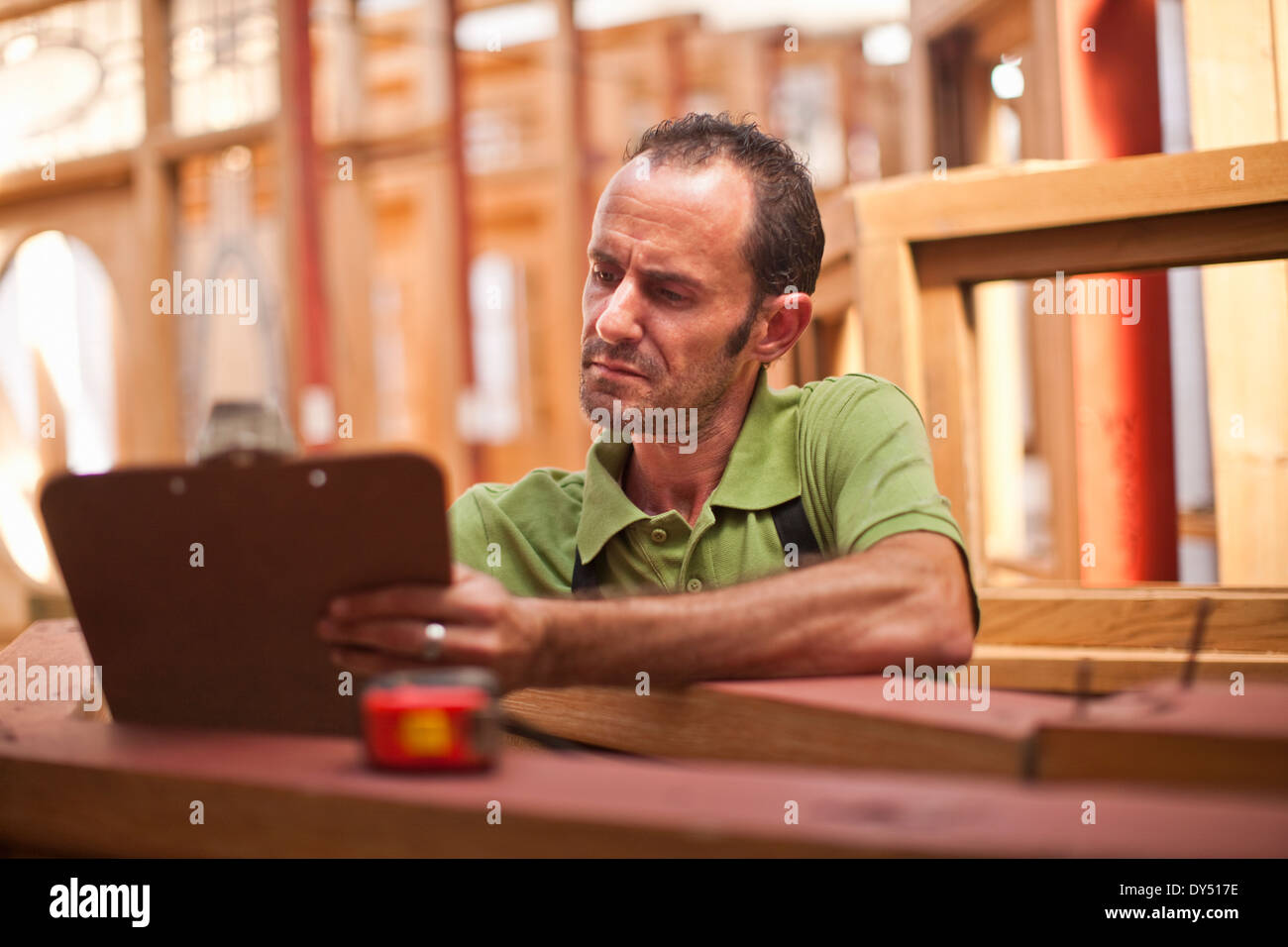 Carpenter writing on clipboard Stock Photo - Alamy