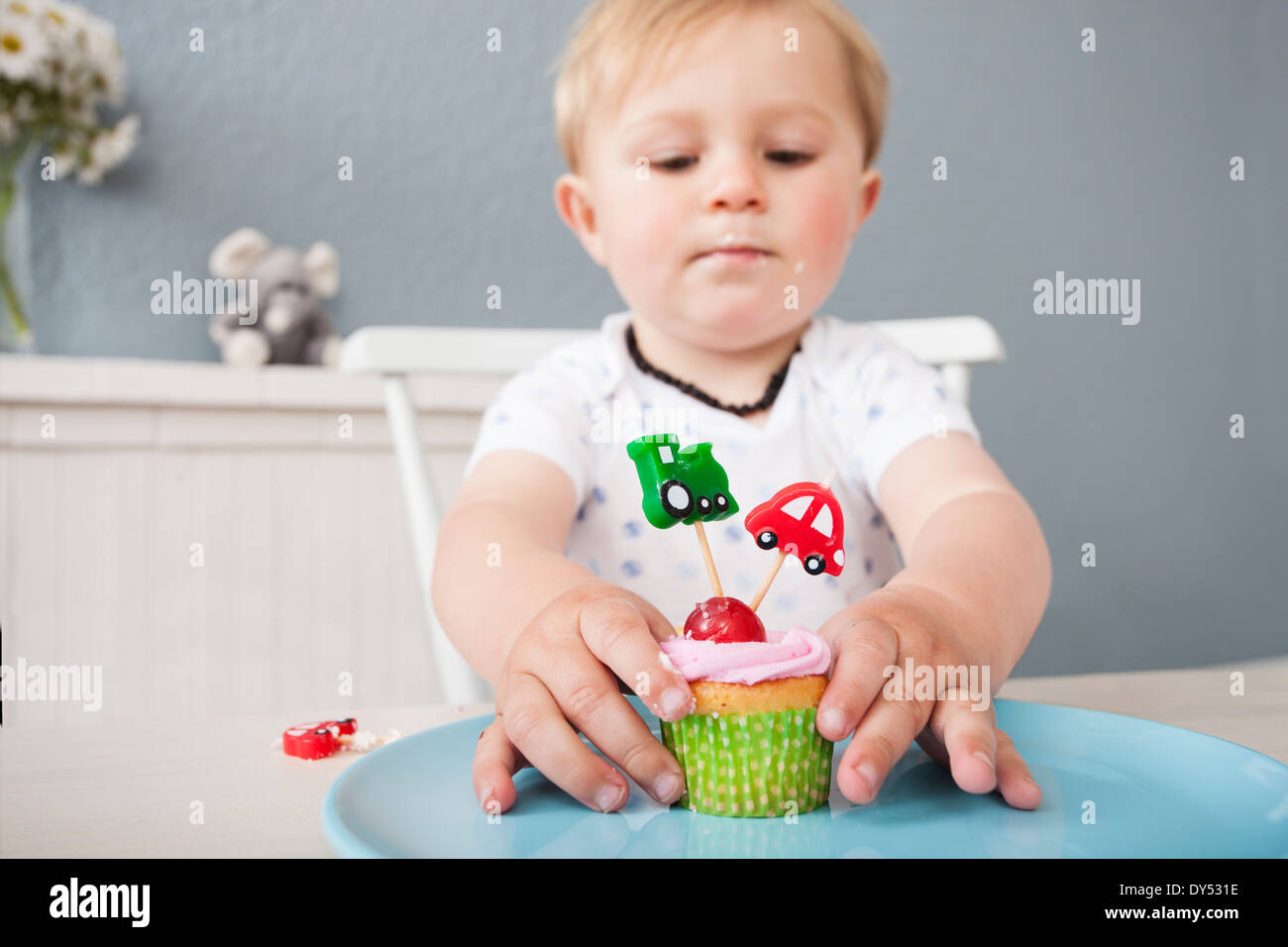 Baby boy playing with cupcake Stock Photo - Alamy