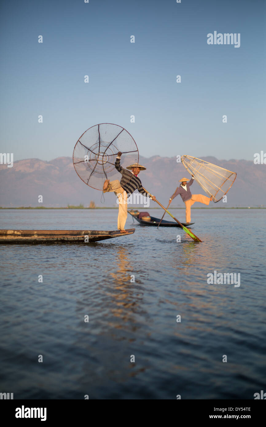 Two Burmese fisherman display traditional methods to catch fish on Inle ...